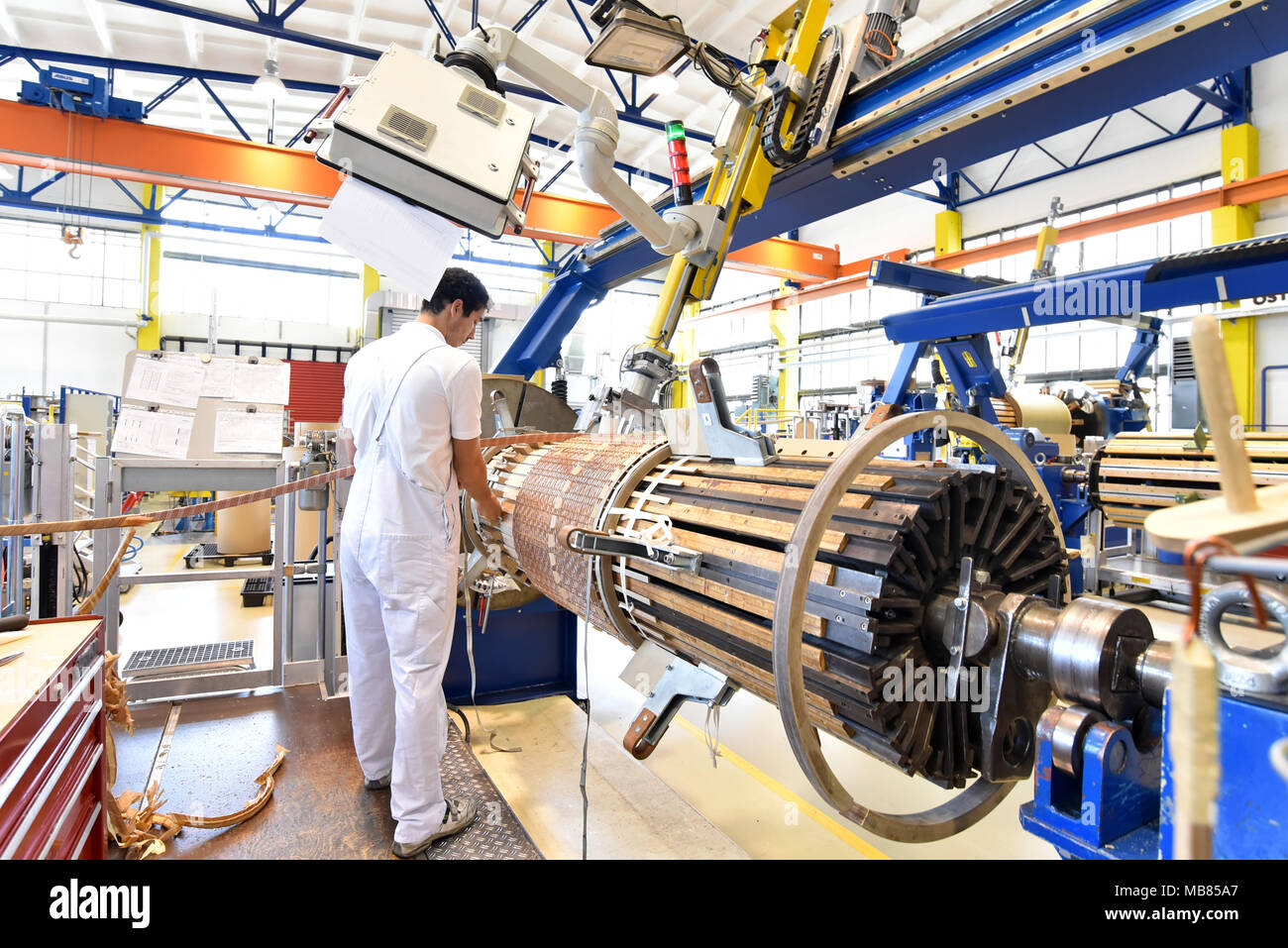 young mechanical engineering workers operate a machine for winding ...