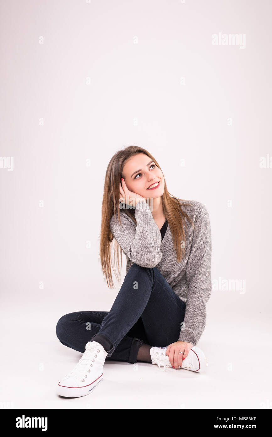 Young beautiful woman posing on white floor. Smiling female model full ...