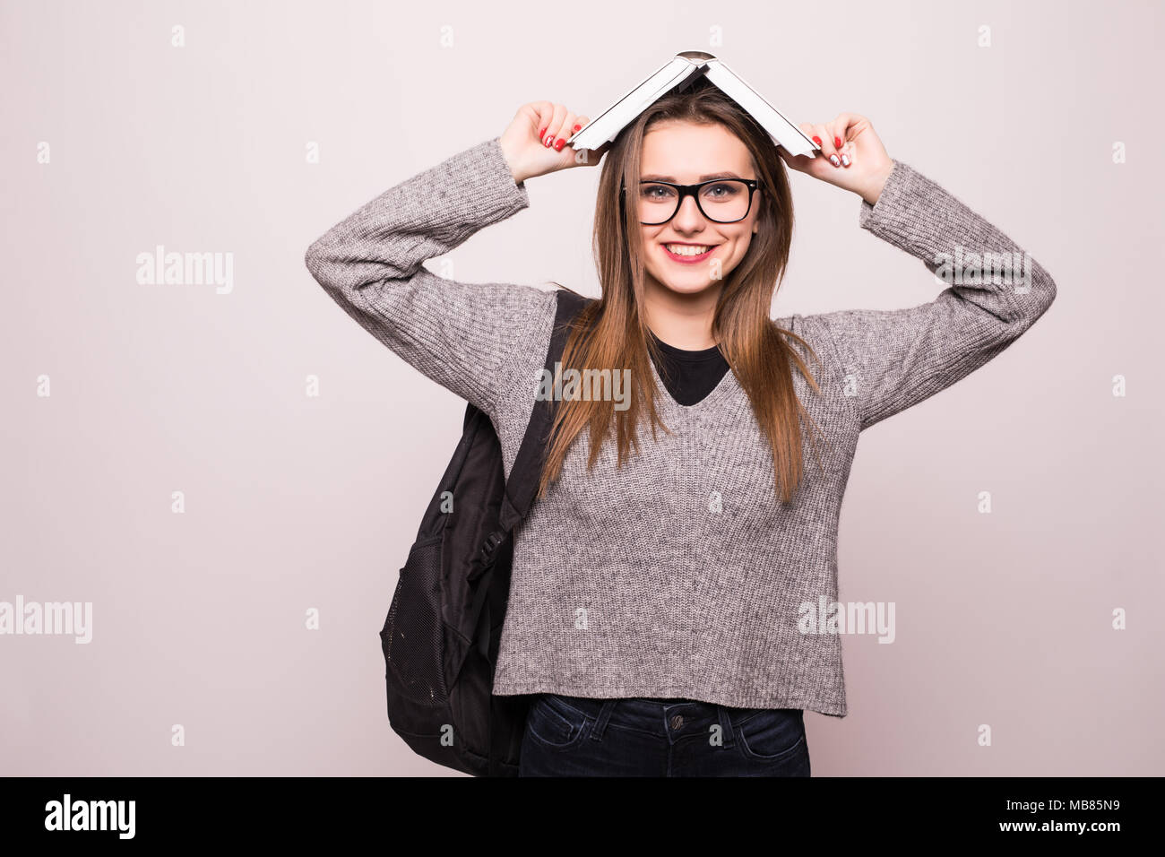 Female student, holding book on head. Isolated on white background ...