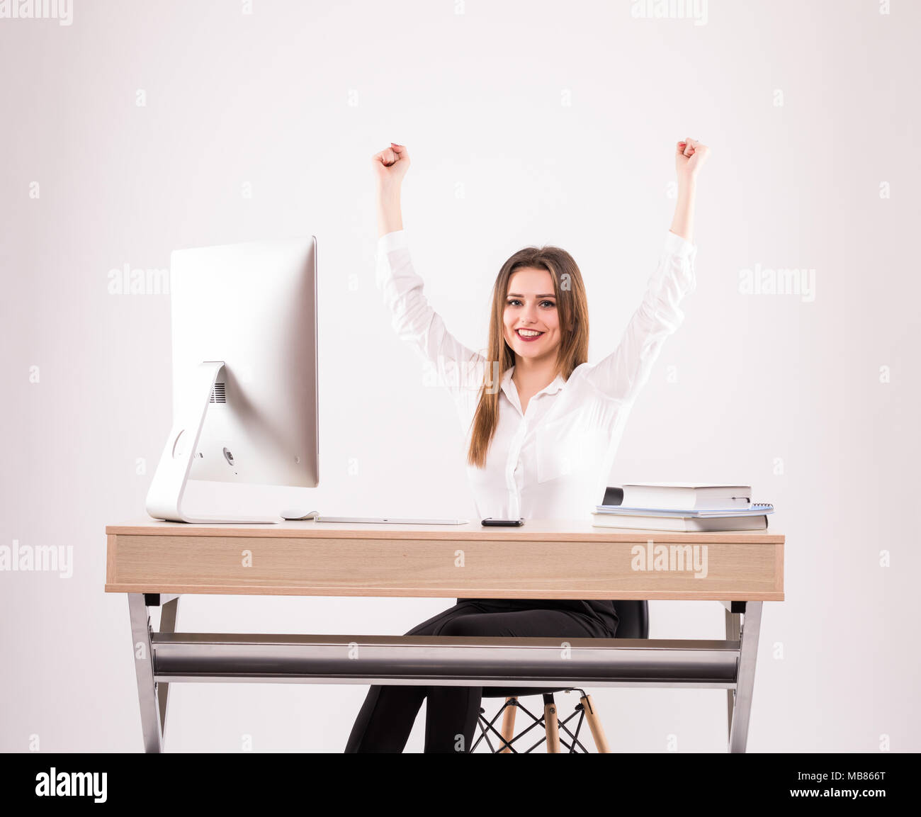 Excited businesswoman at desk with laptop computer isolated on white ...