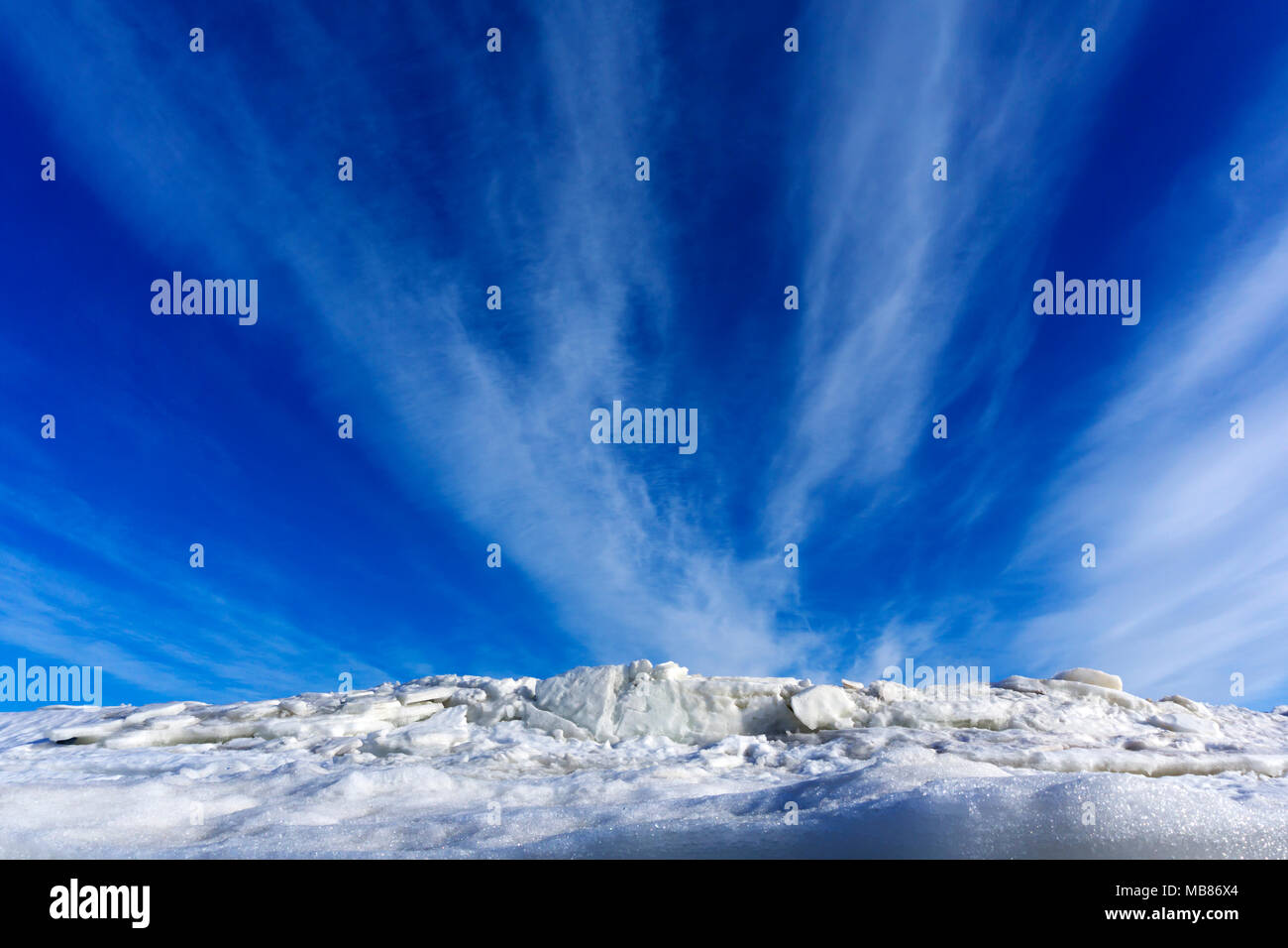 bright blue spring sky with cirrus clouds over melting ice and snow ...