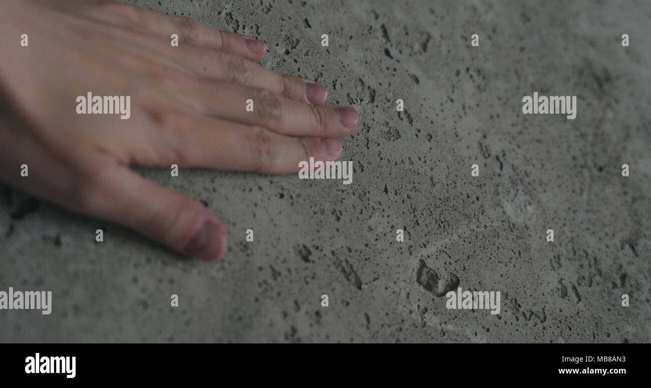 handheld of man hand touching concrete wall, wide photo Stock Photo - Alamy