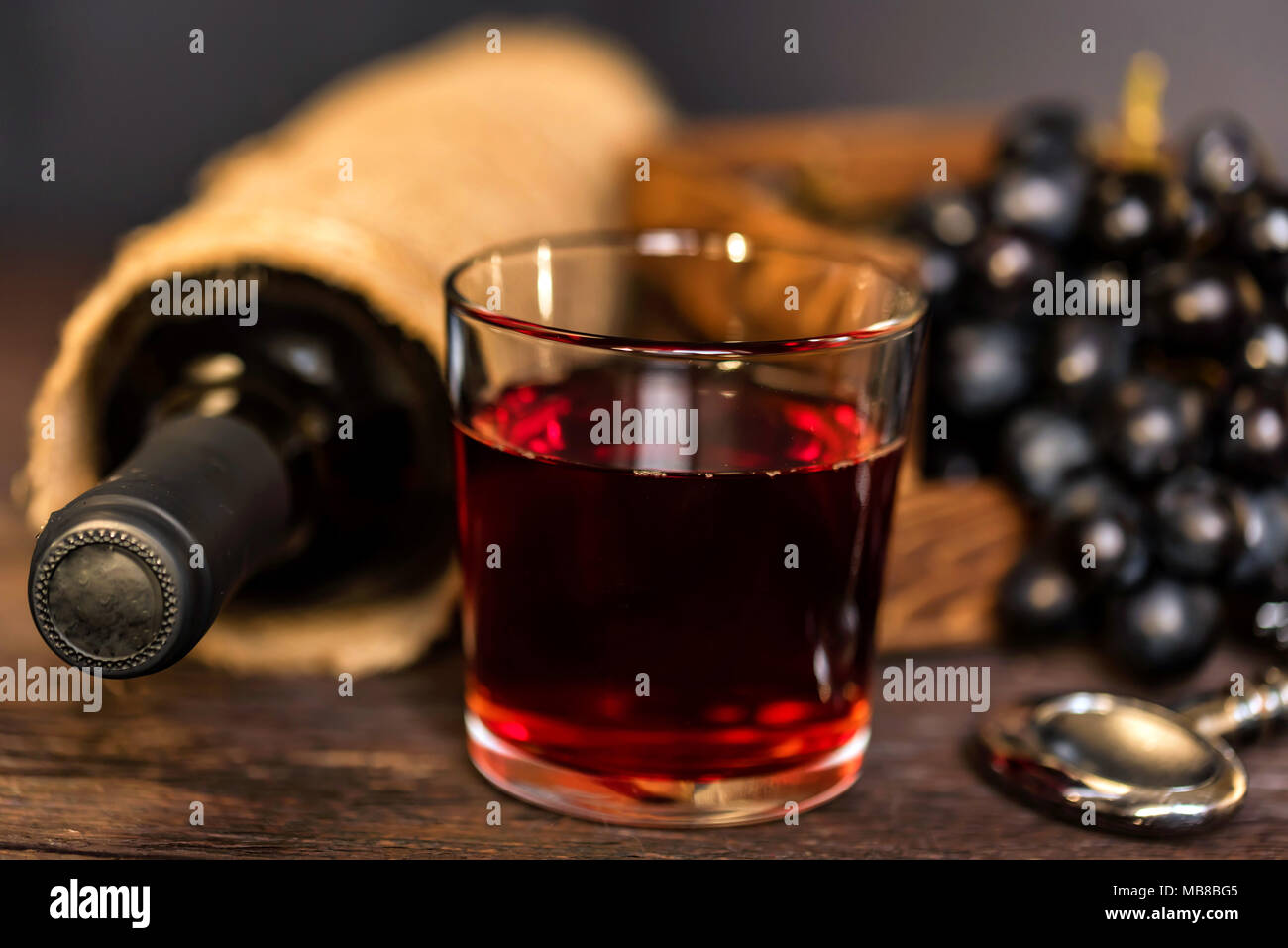 Glass of red wine with bottle and grapes Stock Photo - Alamy
