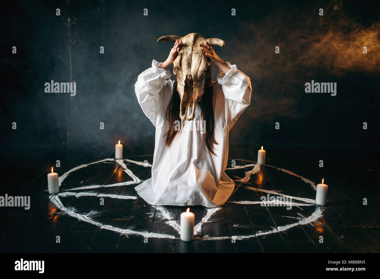 Young woman in white shirt holds skull of the animal in hands ...