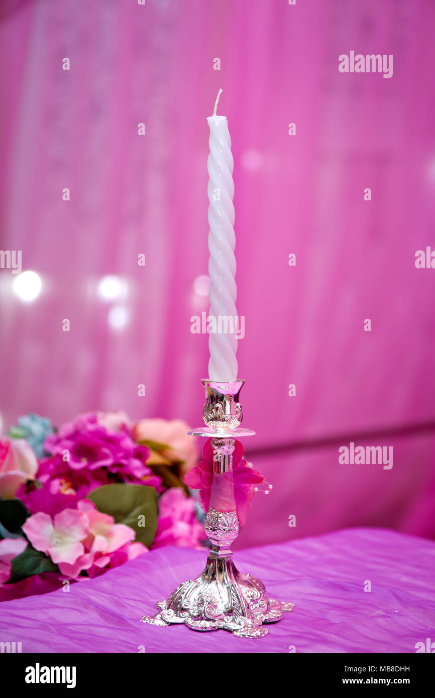 Beautiful candle on pink background . Candle in candlestick burning ...