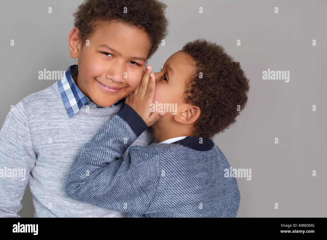 Two brothers wearing casual clothes studio isolated on grey background ...
