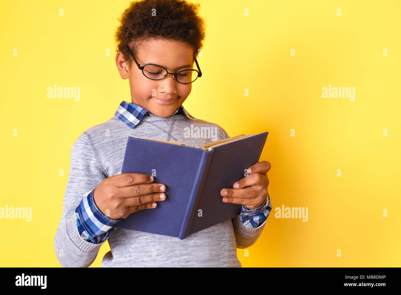 One teeneager boy student wearing eyeglasses studio isolated on yellow ...