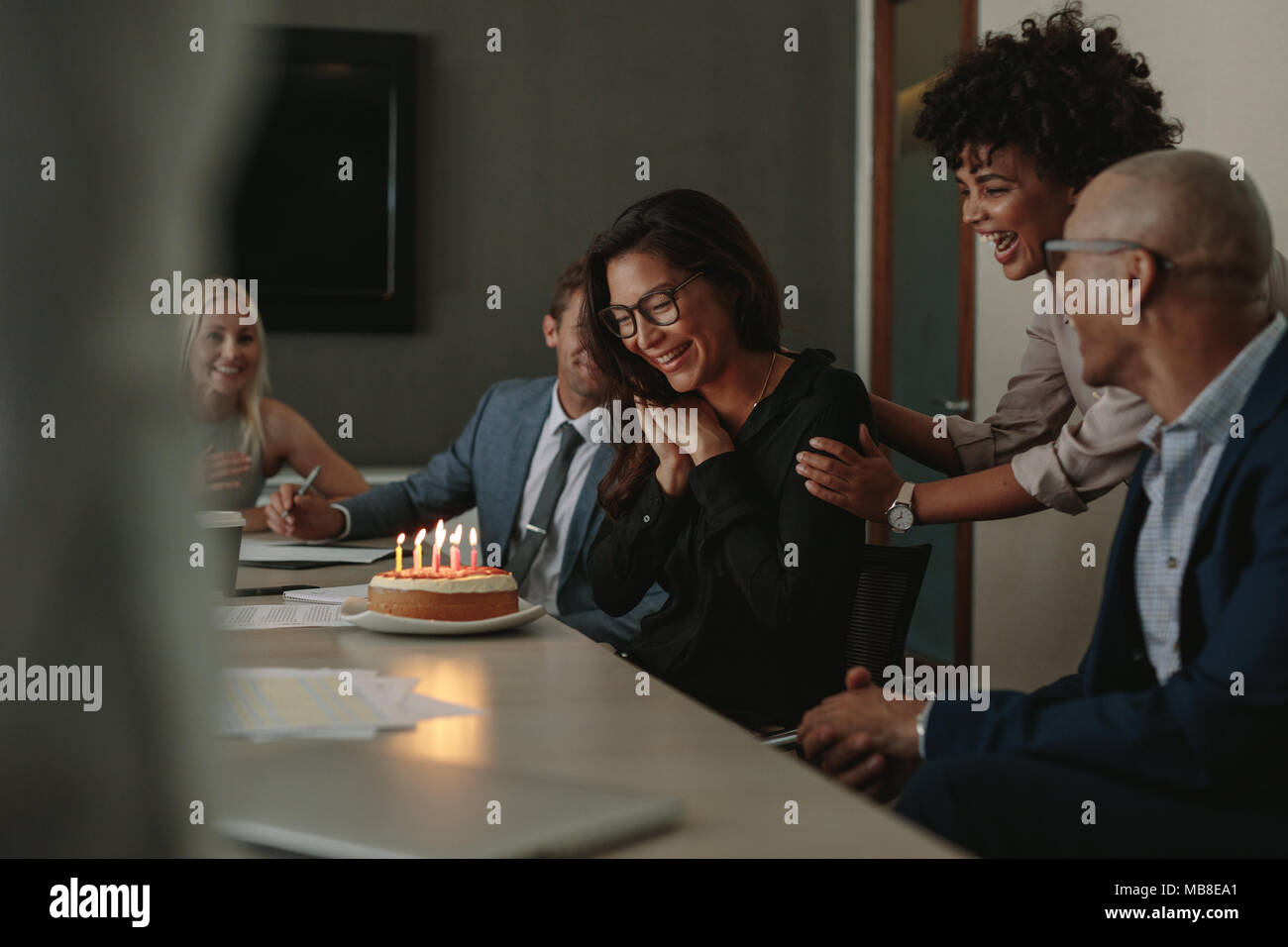 business team celebrating female colleague's birthday with cake in ...