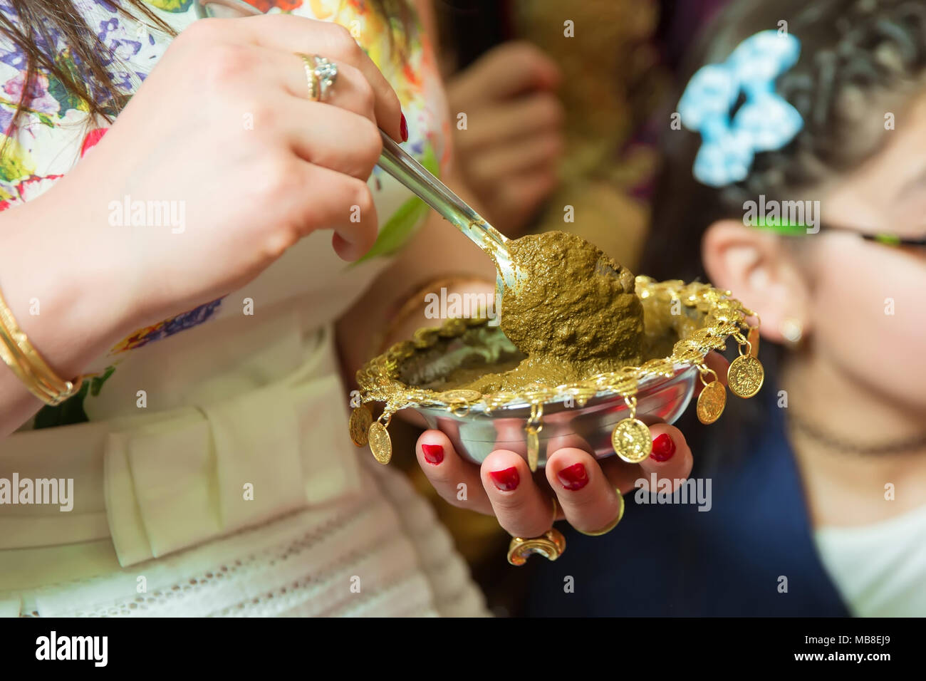 Female hands decoratively colored by henna with cup . Hold a bowl with ...
