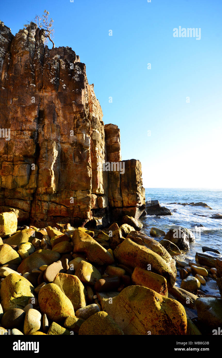Rocks at bottom of cliff by ocean Stock Photo - Alamy
