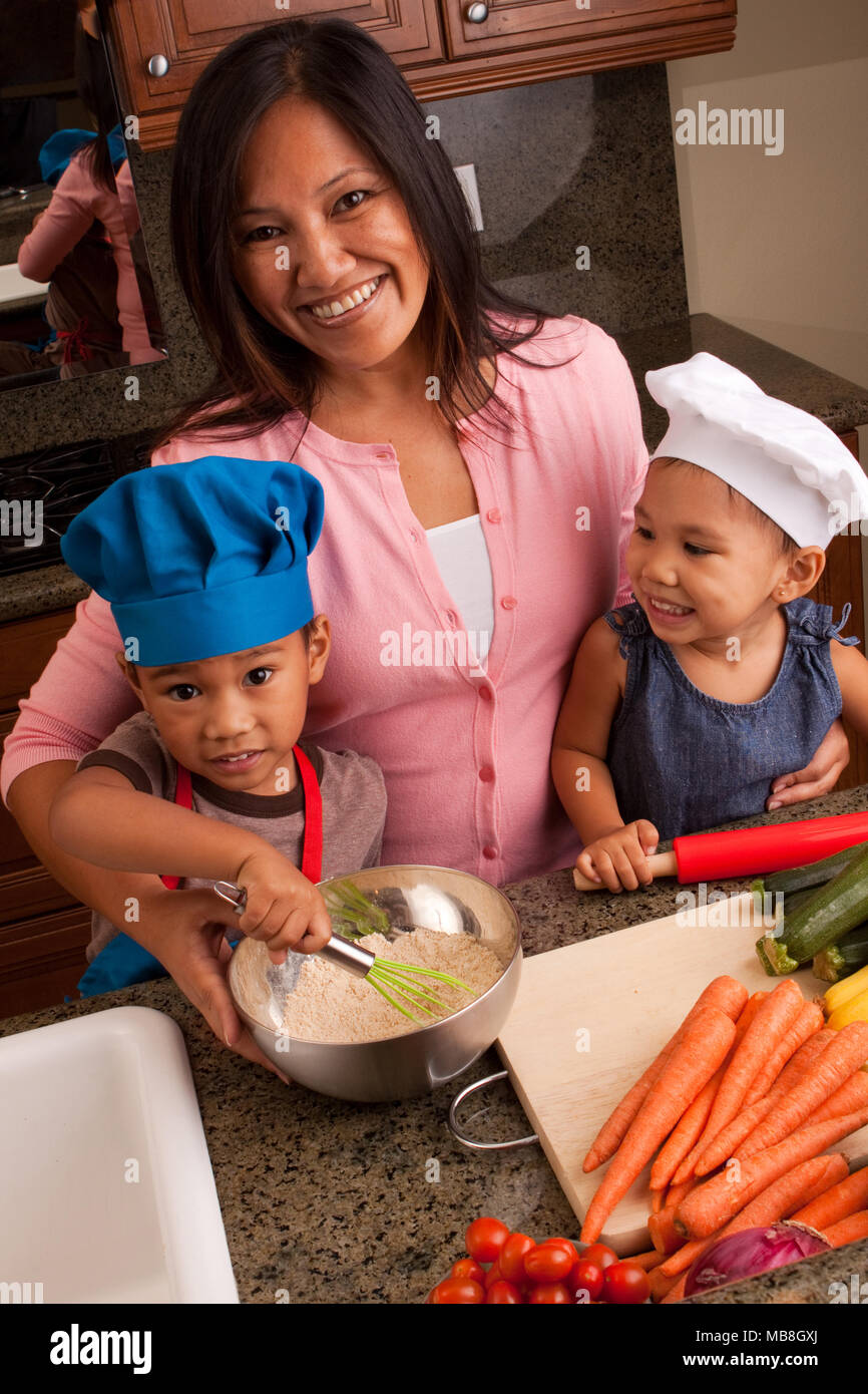 Mother and her children cooking in the kitchen Stock Photo - Alamy