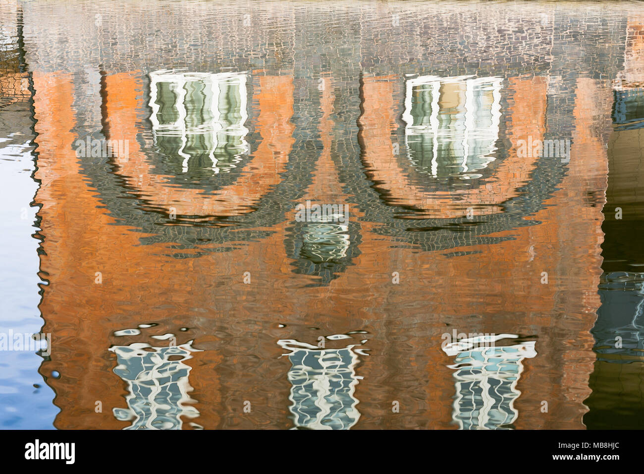 Abstract water reflections of an old red brick building in Worcester ...