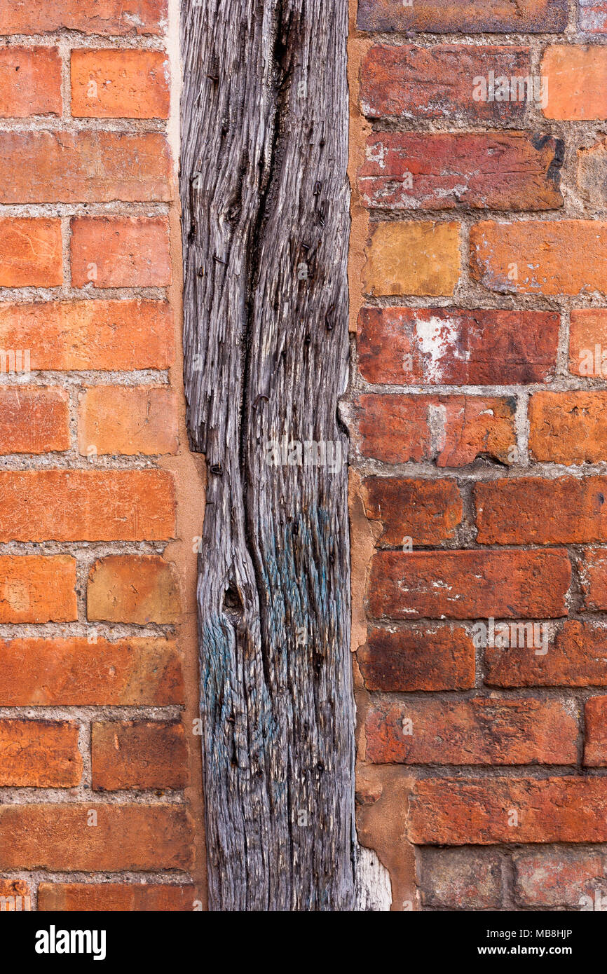 Old red brick wall with vertical wooden beam Stock Photo - Alamy