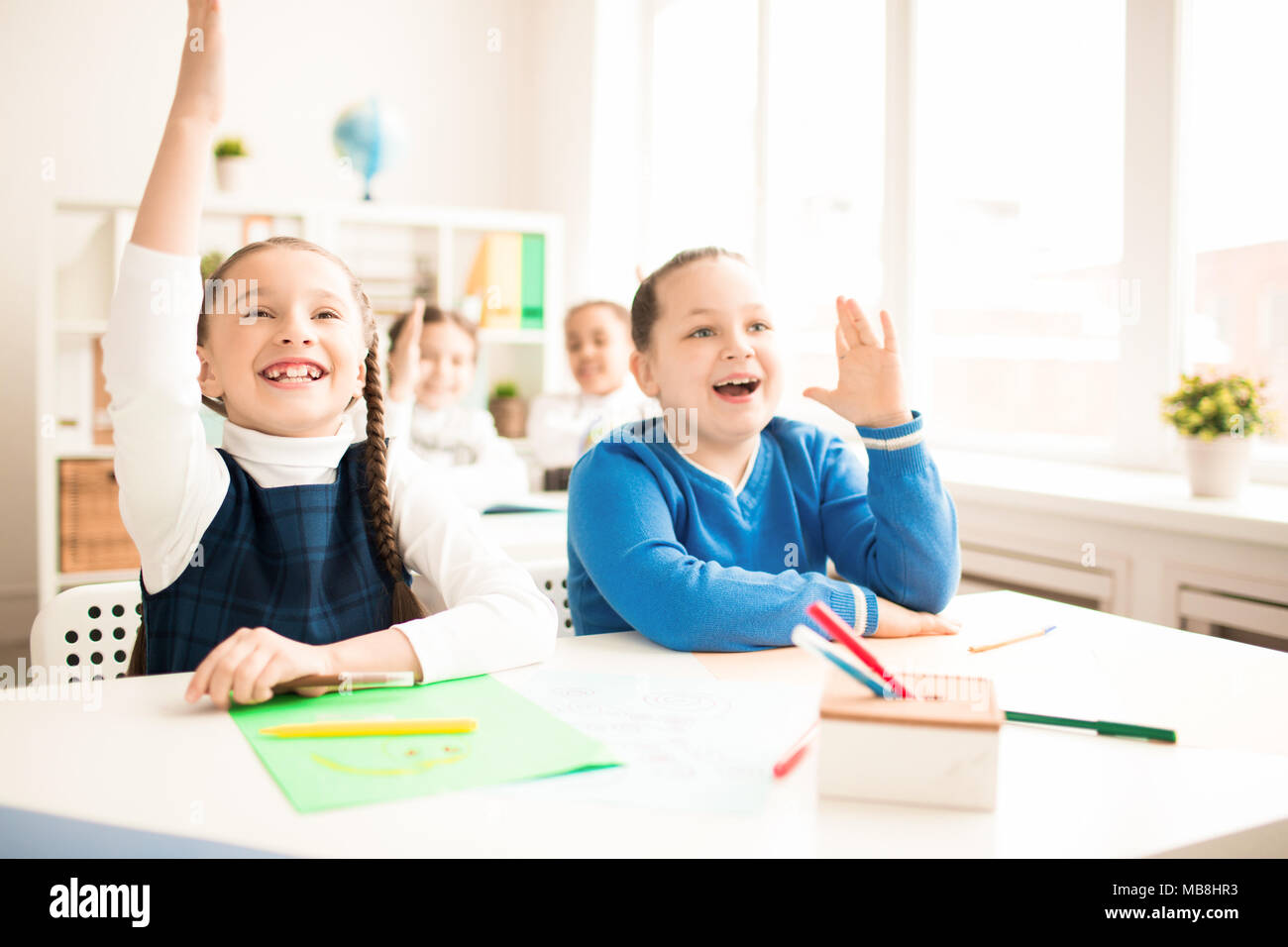 Kids raising hands classroom hi-res stock photography and images - Alamy