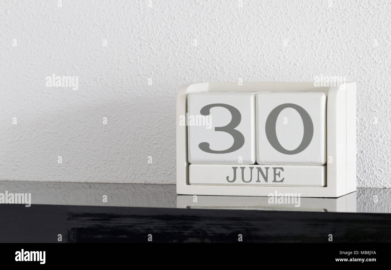 White block calendar present date 30 and month June on white wall ...