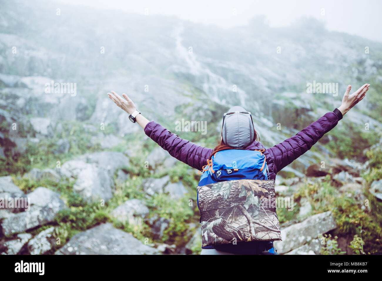Photo from back of woman with backpack with hands up Stock Photo - Alamy