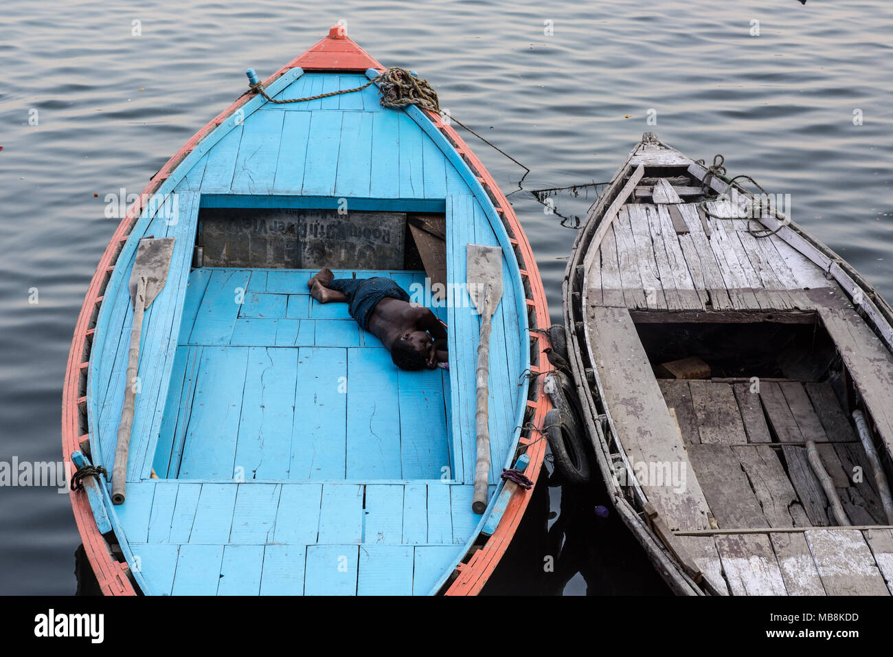 Brightly colored row boats lined up on the Ganges river in Varanasi ...