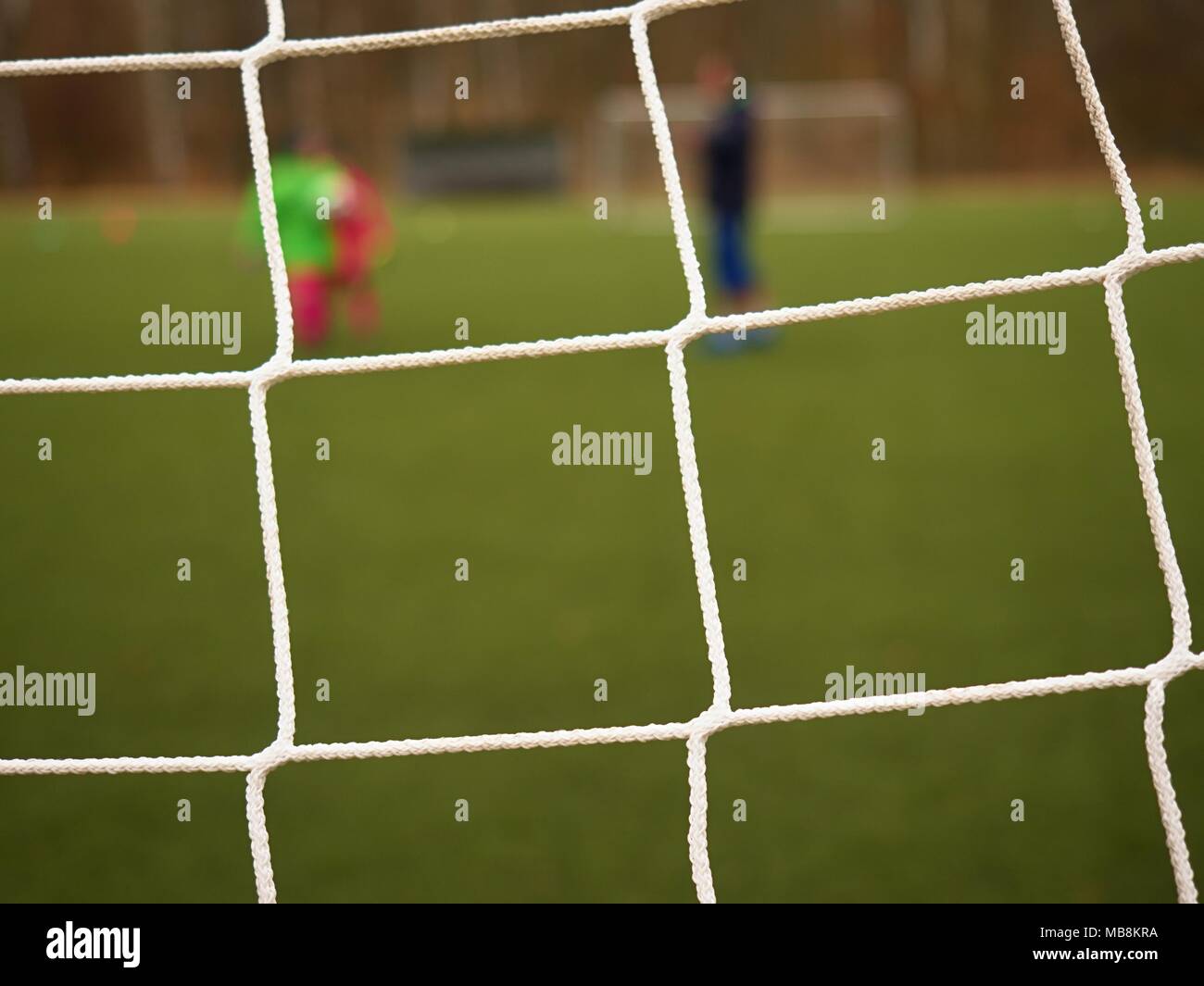 Football player stands against goal with net and stadium. Football gate ...