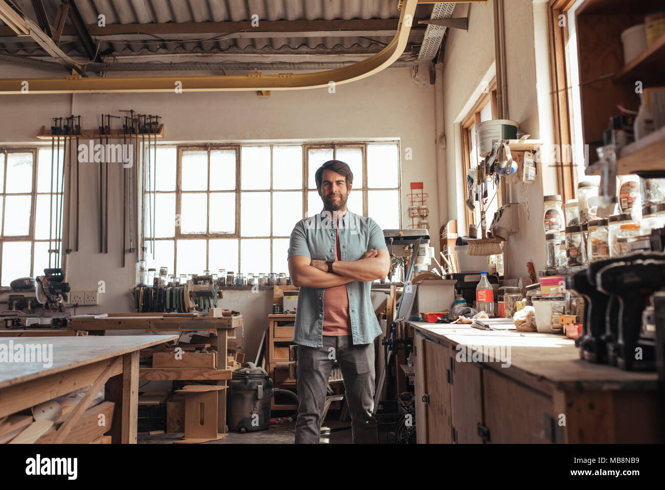 Confident young woodworker standing in his workshop full of tools Stock ...