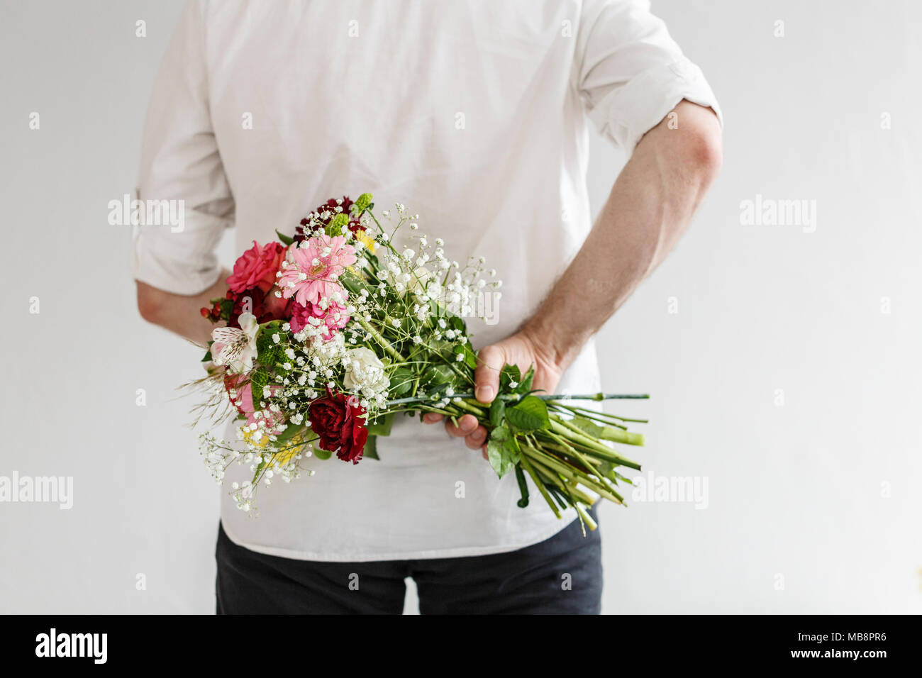 Man holding roses behind back hi-res stock photography and images - Alamy