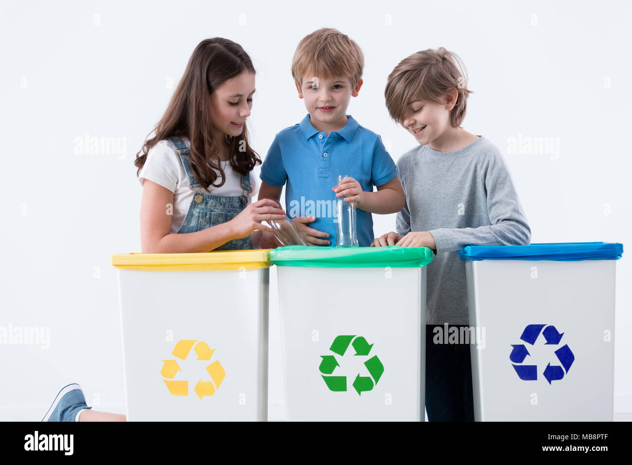 Kids segregating trash into different colored bins Stock Photo - Alamy
