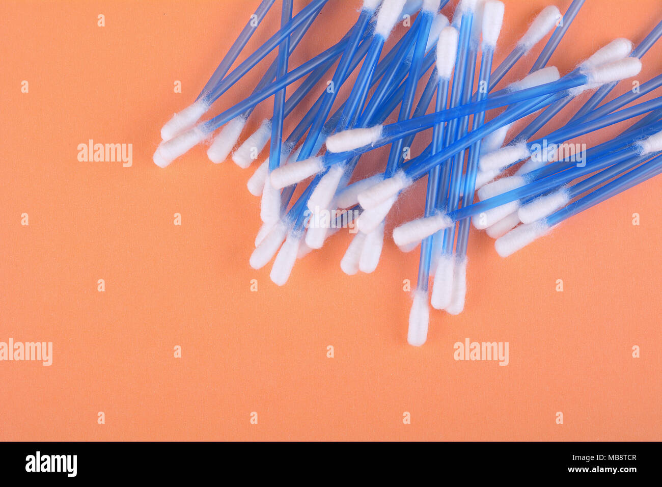 Stack of cotton buds on orange background. Healthcare concept Stock ...