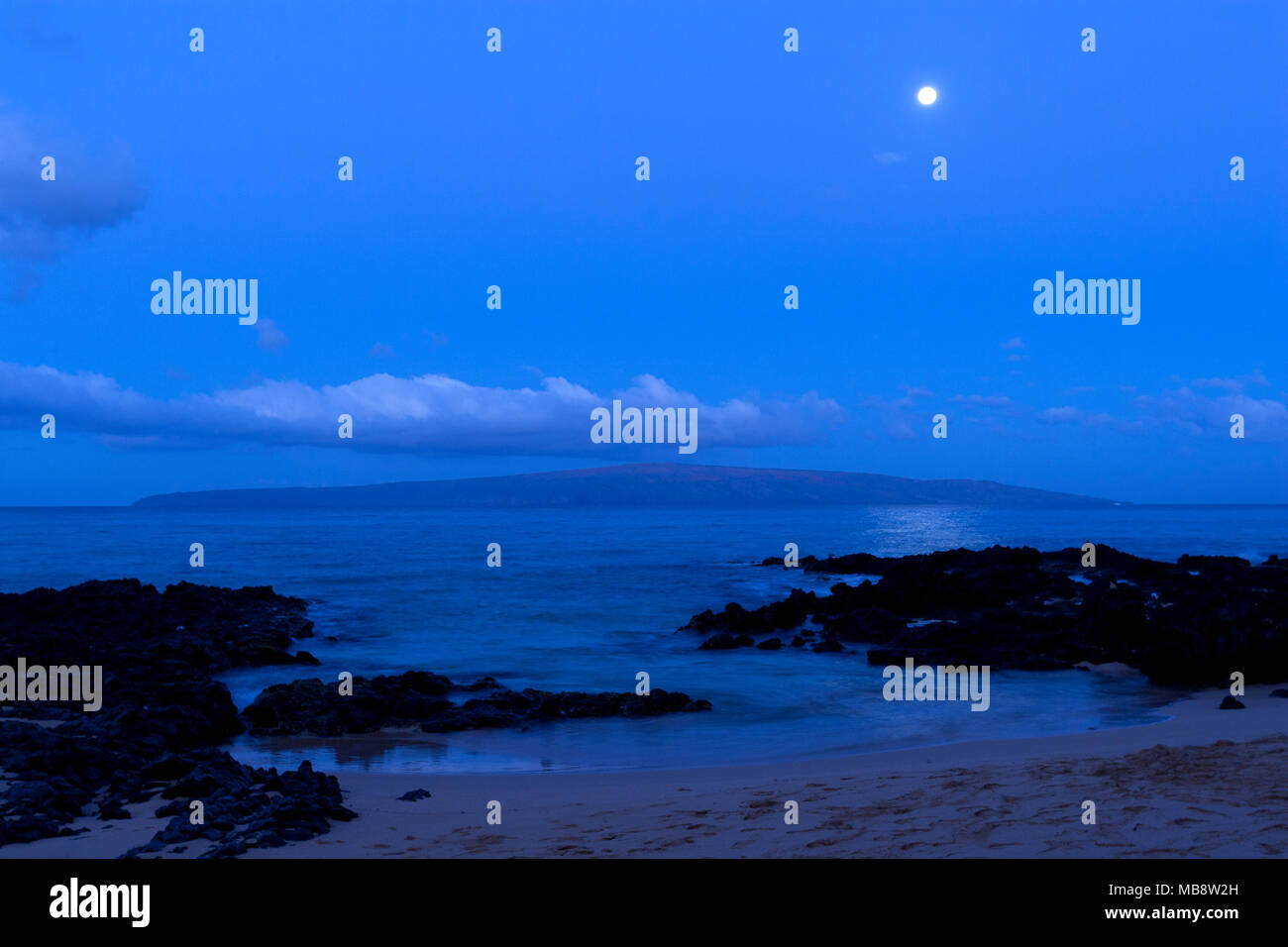 Full moon sets over the island of Kahoolawe at Makena, Maui, Hawaii ...