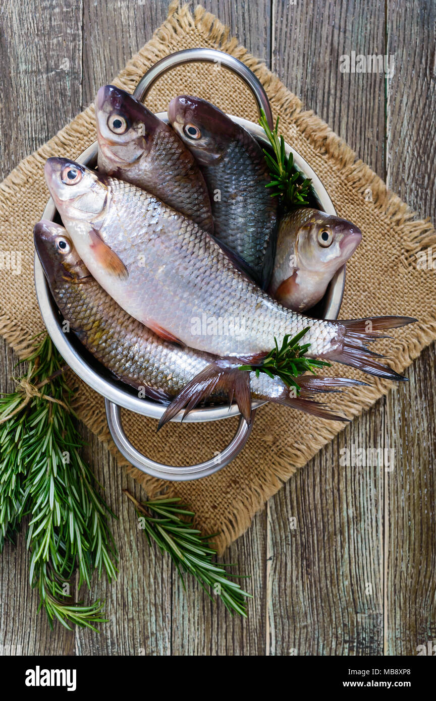 A pile of fresh raw fish on a wooden background. Top view. Carp. Fresh ...
