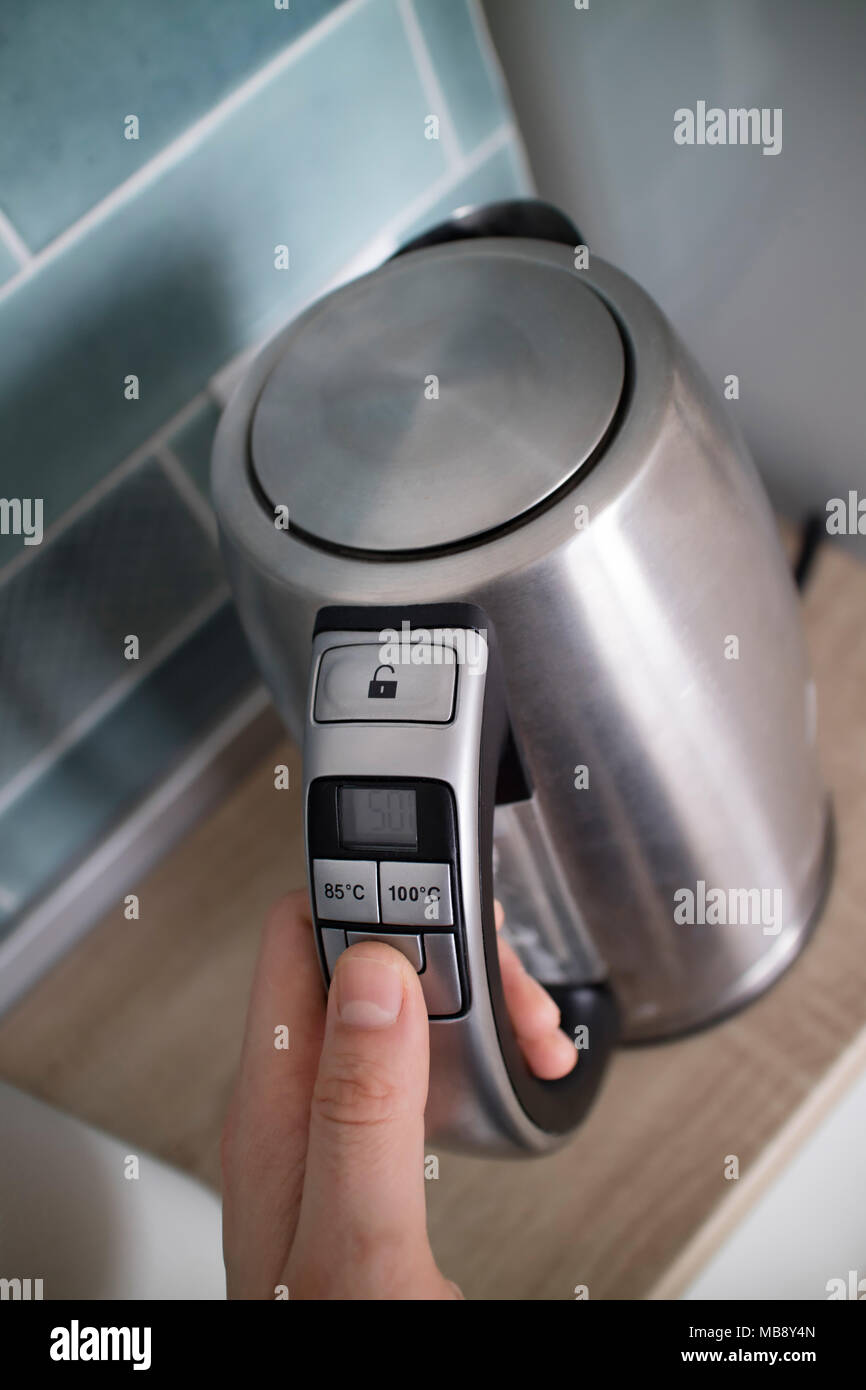 metal kettle in the kitchen in the man hand on a kitchen Stock Photo ...