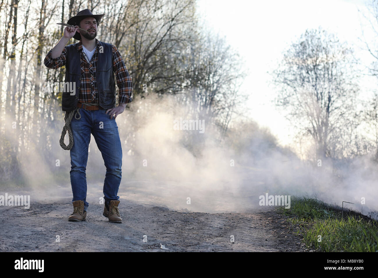 A cowboy in a thick smoke on the road Stock Photo - Alamy