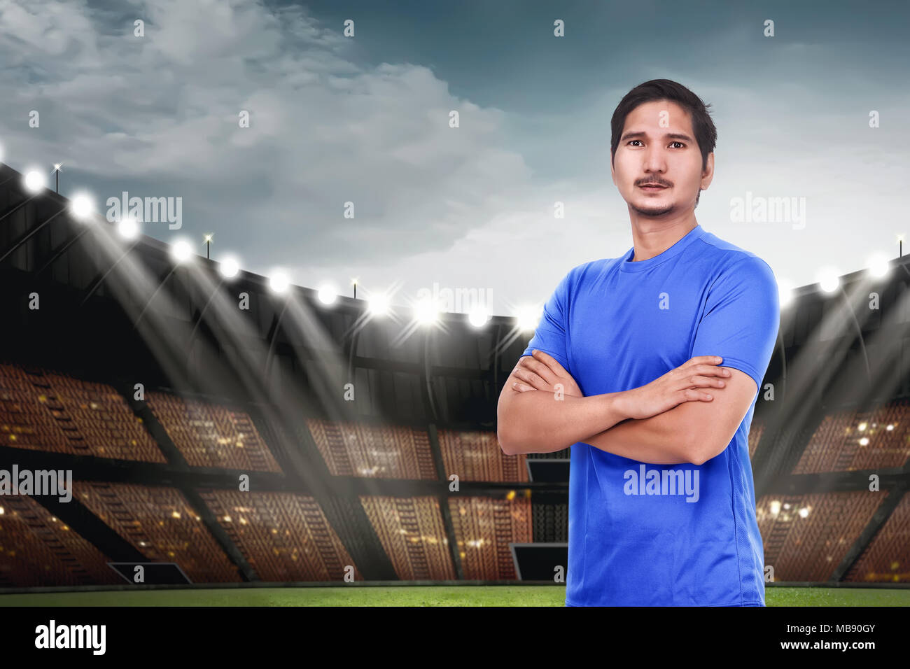 Young asian footballer standing with crossed arms on the stadium Stock ...