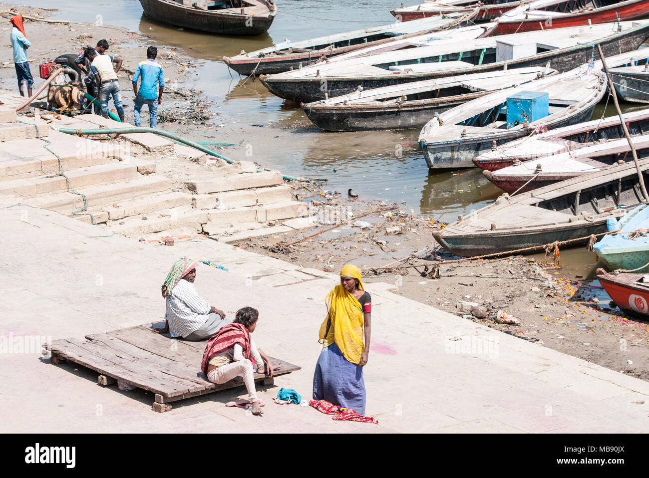 Varanasi, India - March 12, 2017: People and colorful boats at the bank ...