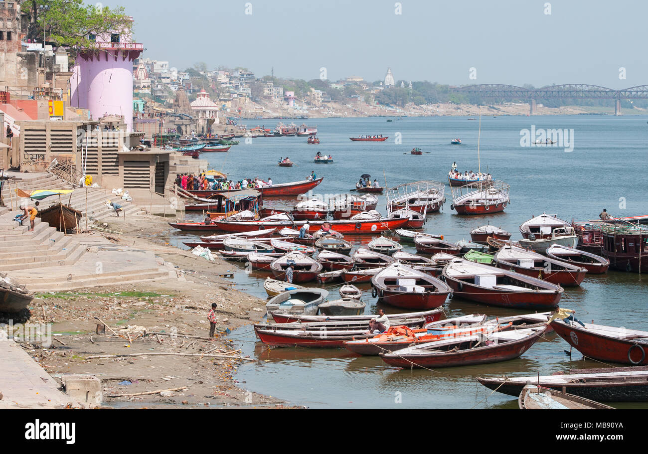 Varanasi, India - March 12 2017: People and colorful boats at the bank ...