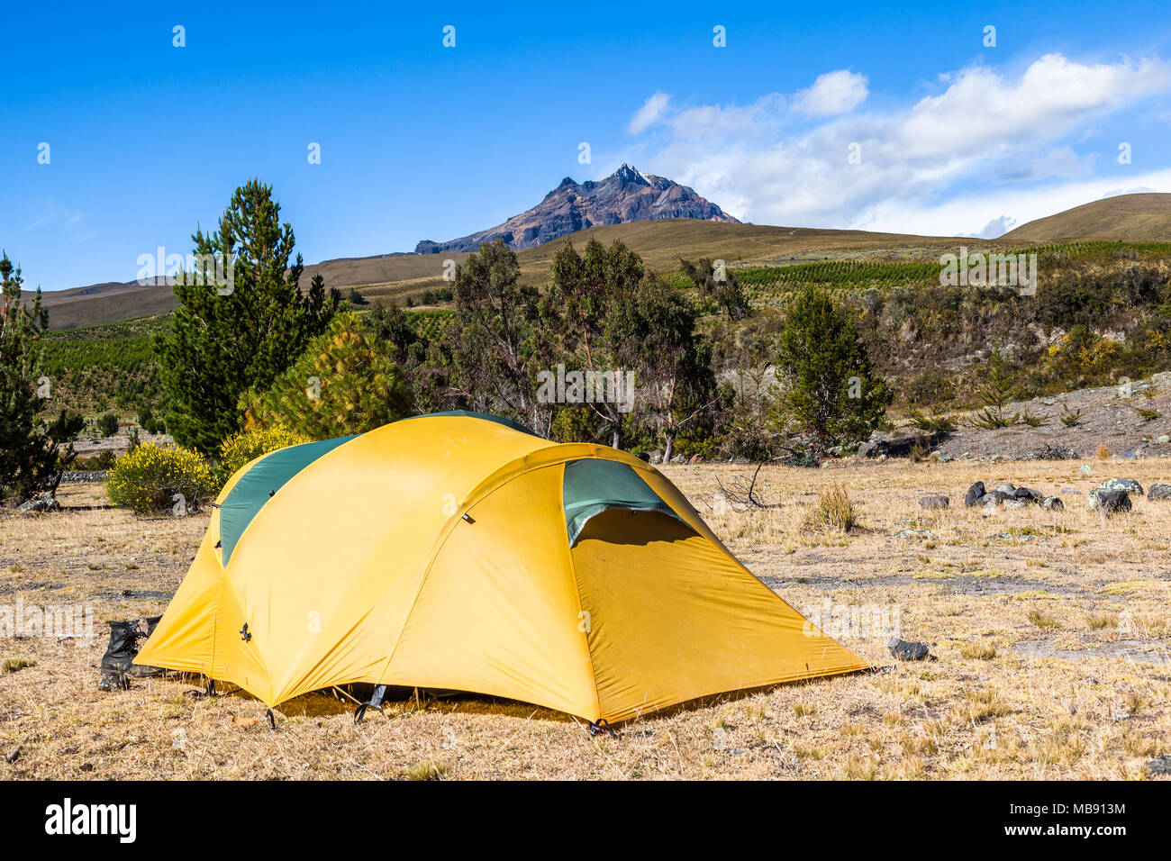 Camping with yellow tent in the lowlands of Sincholagua volcano on a ...