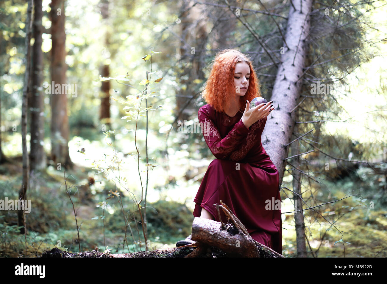 The red-haired witch holds a ritual with a crystal ball Stock Photo - Alamy