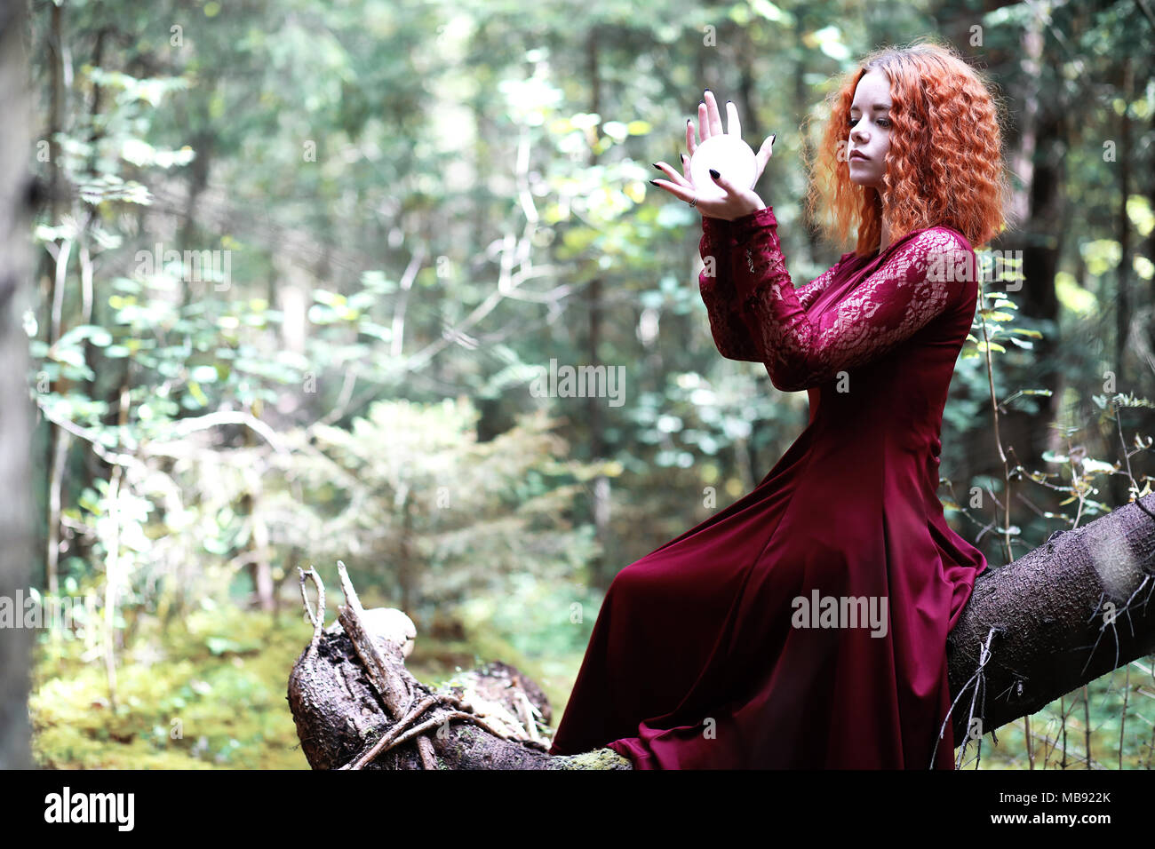 The red-haired witch holds a ritual with a crystal ball Stock Photo - Alamy