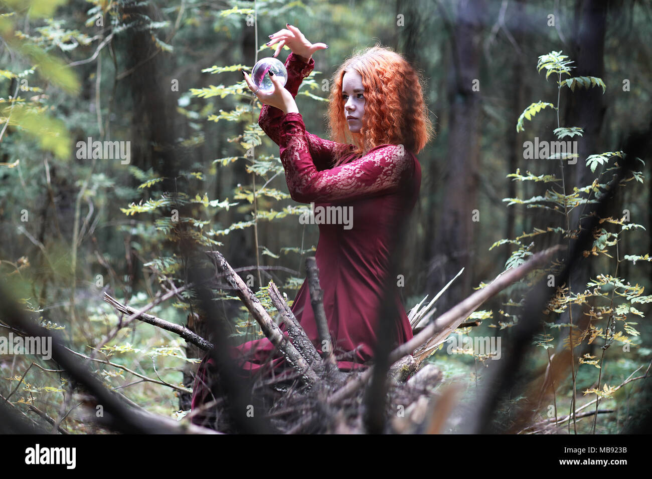 The red-haired witch holds a ritual with a crystal ball Stock Photo - Alamy