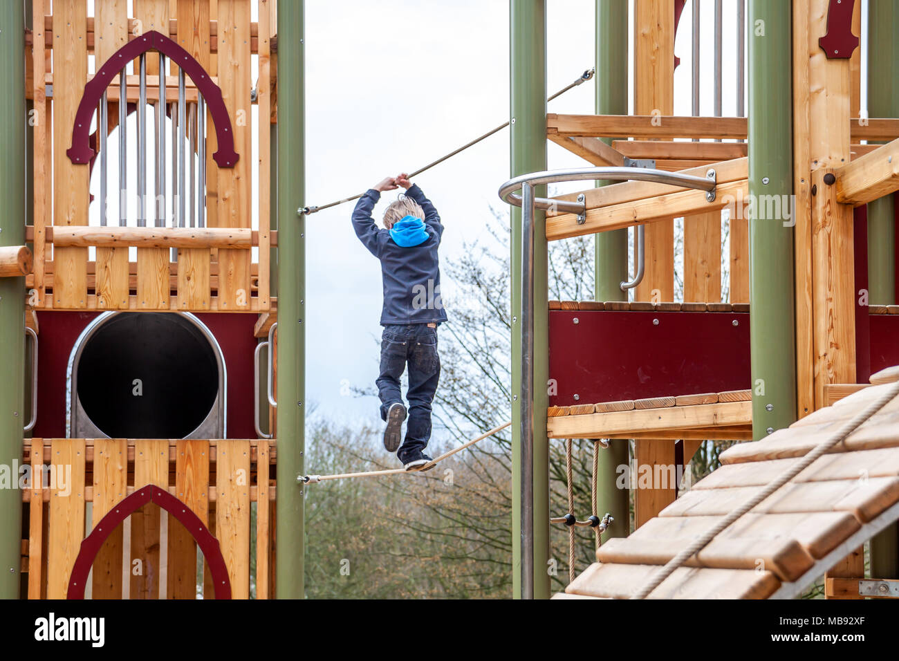 Happy boy climbing rope on the playground outdoors Stock Photo - Alamy
