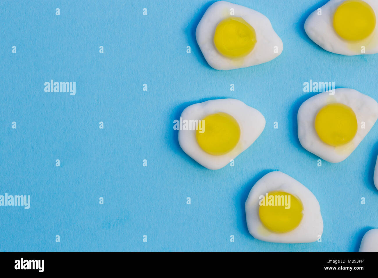Fried eggs candy sweets overhead on bright blue background Stock Photo ...