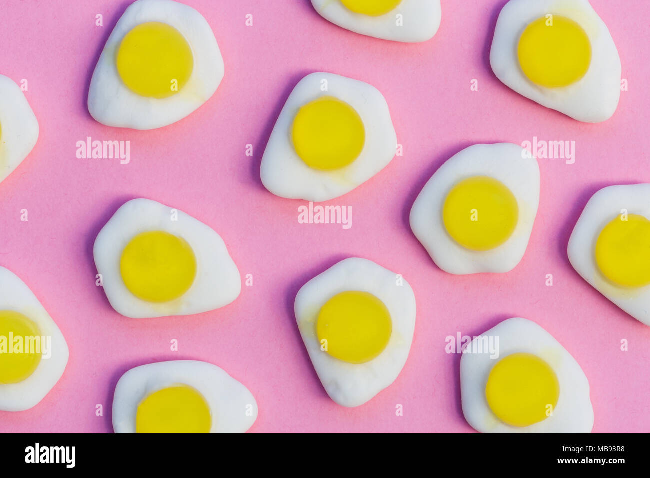 Fried eggs candy sweets on bright pink background Stock Photo - Alamy