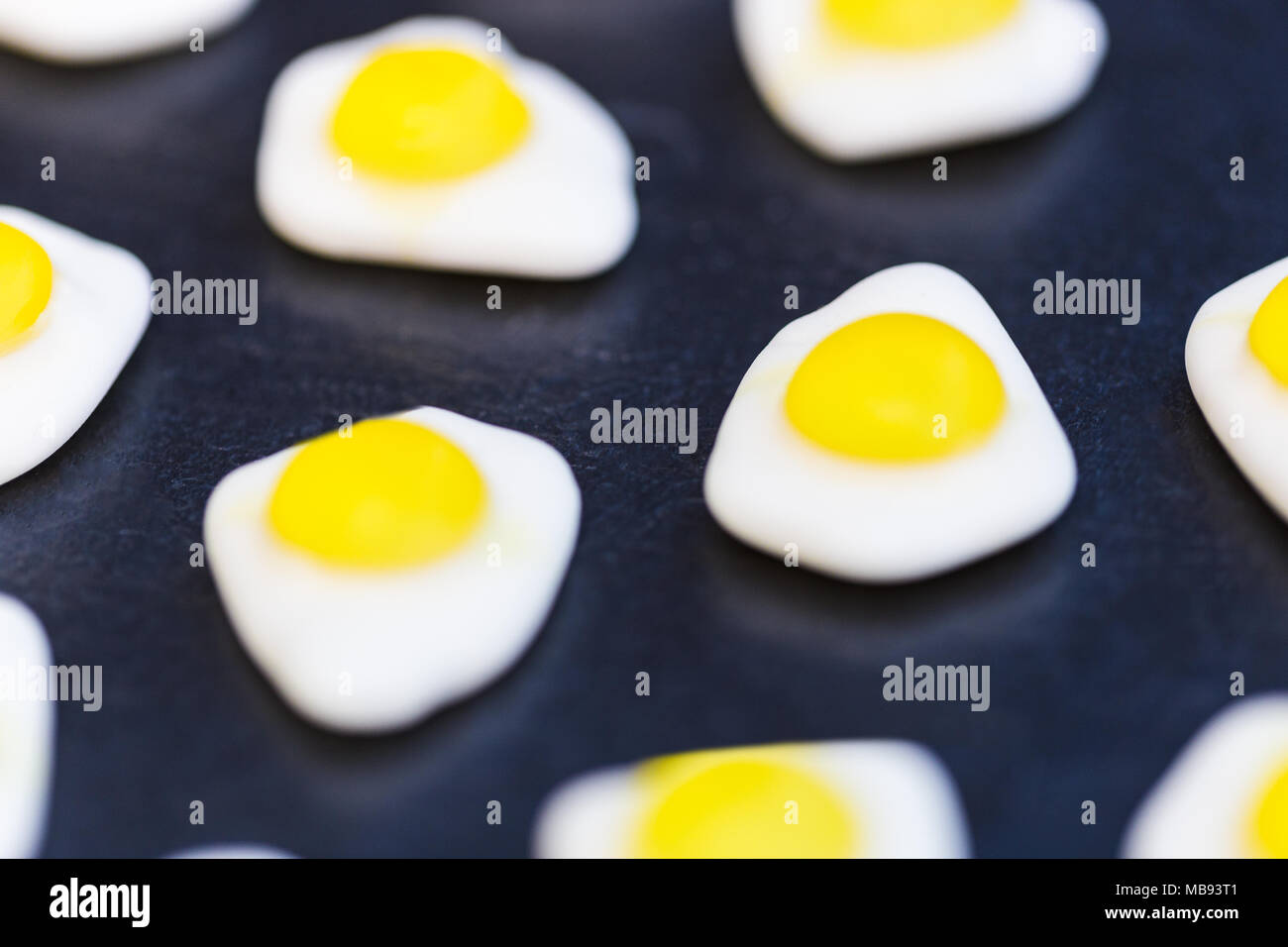 Fried eggs candy sweets closeup on dark background Stock Photo - Alamy