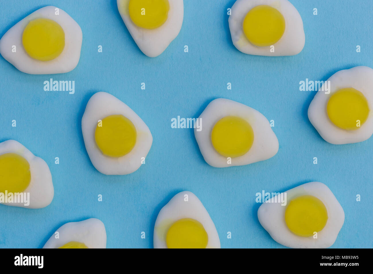 Fried eggs candy sweets overhead on bright blue background Stock Photo ...