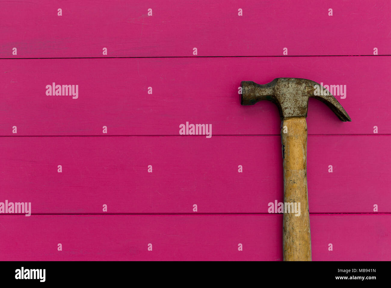 Old hammer on bright pink wood texture background Stock Photo - Alamy