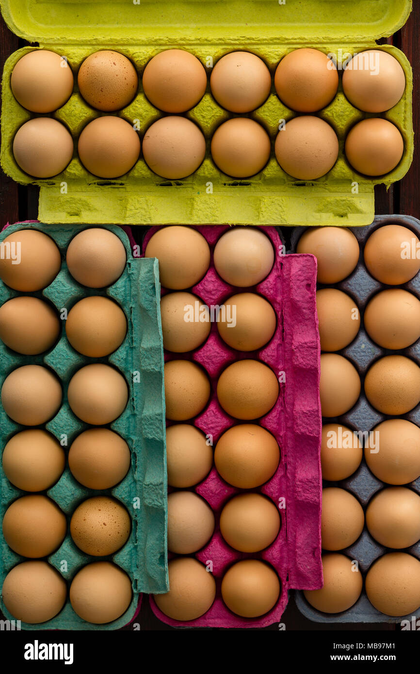 Colorful full cardboard boxes of fresh farm eggs viewed from above in ...