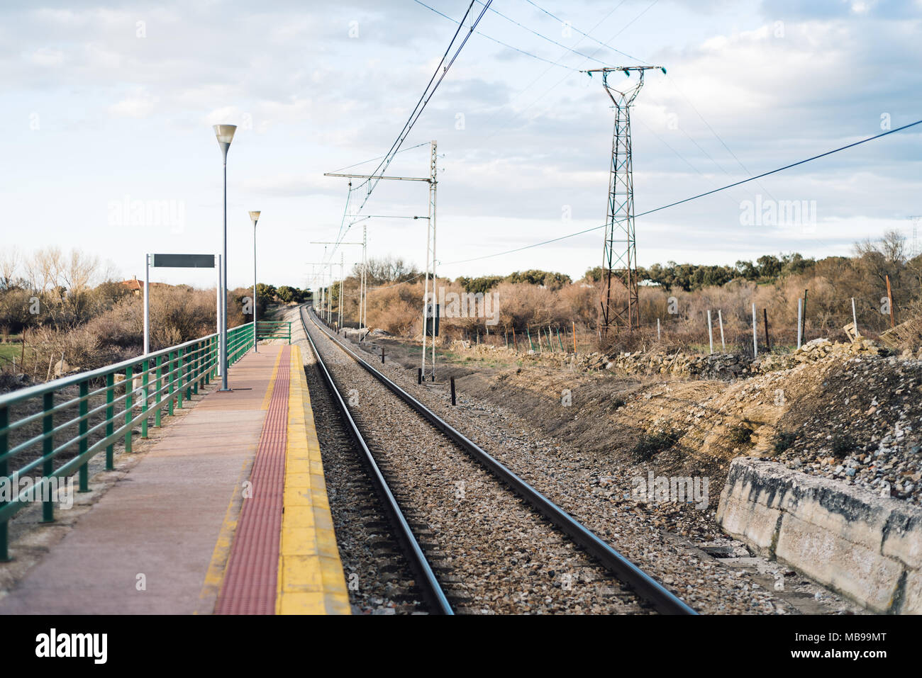 Railroad tracks in rural station platform straight ahead perspective ...