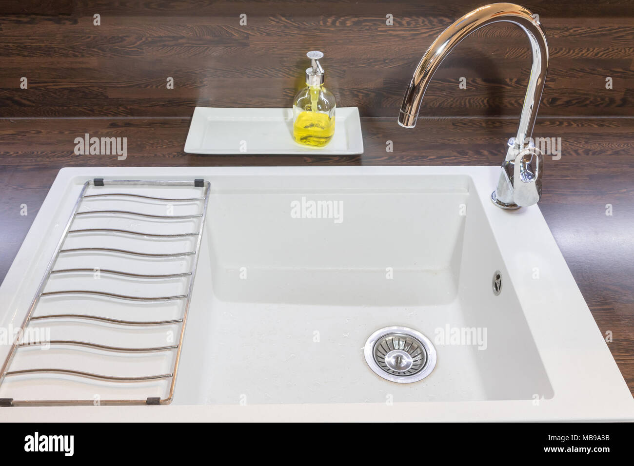 Front view of the white empty kitchen sink. Ready as a background. All ...