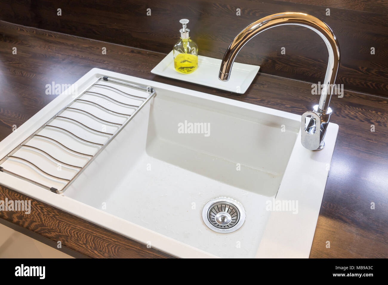 Side view of the white empty kitchen sink. Ready as a background. All ...