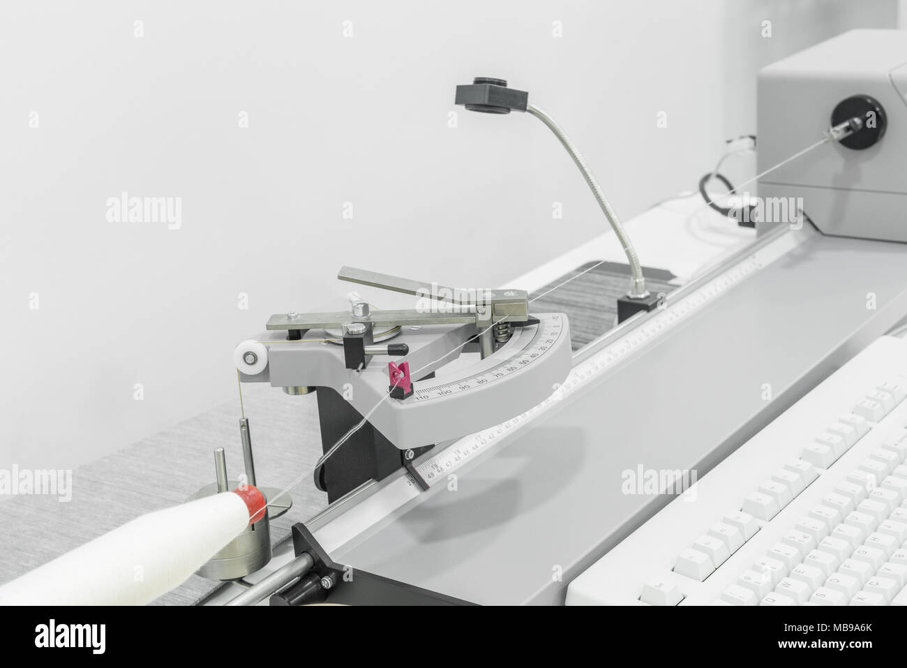 laboratory equipment measures the quality of cotton thread for strength ...