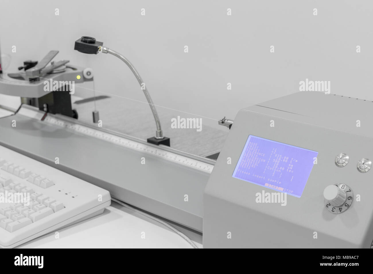laboratory equipment measures the quality of cotton thread for strength ...