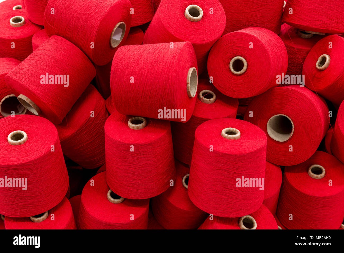 a large pile of spools of red thread. closeup Stock Photo - Alamy
